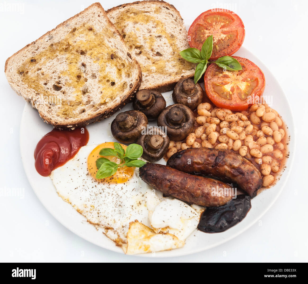 A traditional cooked english fry-up on a plate isolated on a white ...