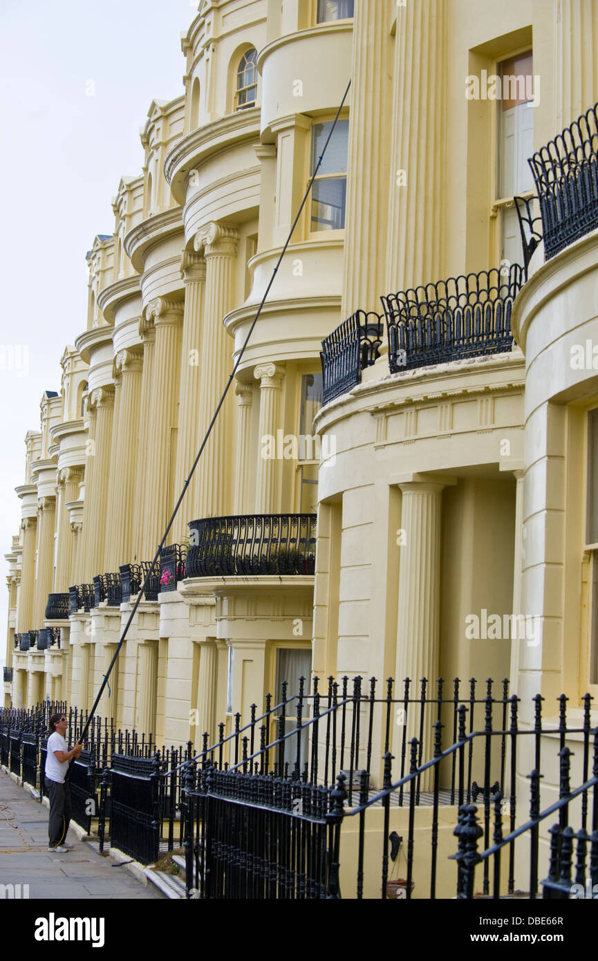 Window cleaner cleaning windows of Regency architecture houses at ...