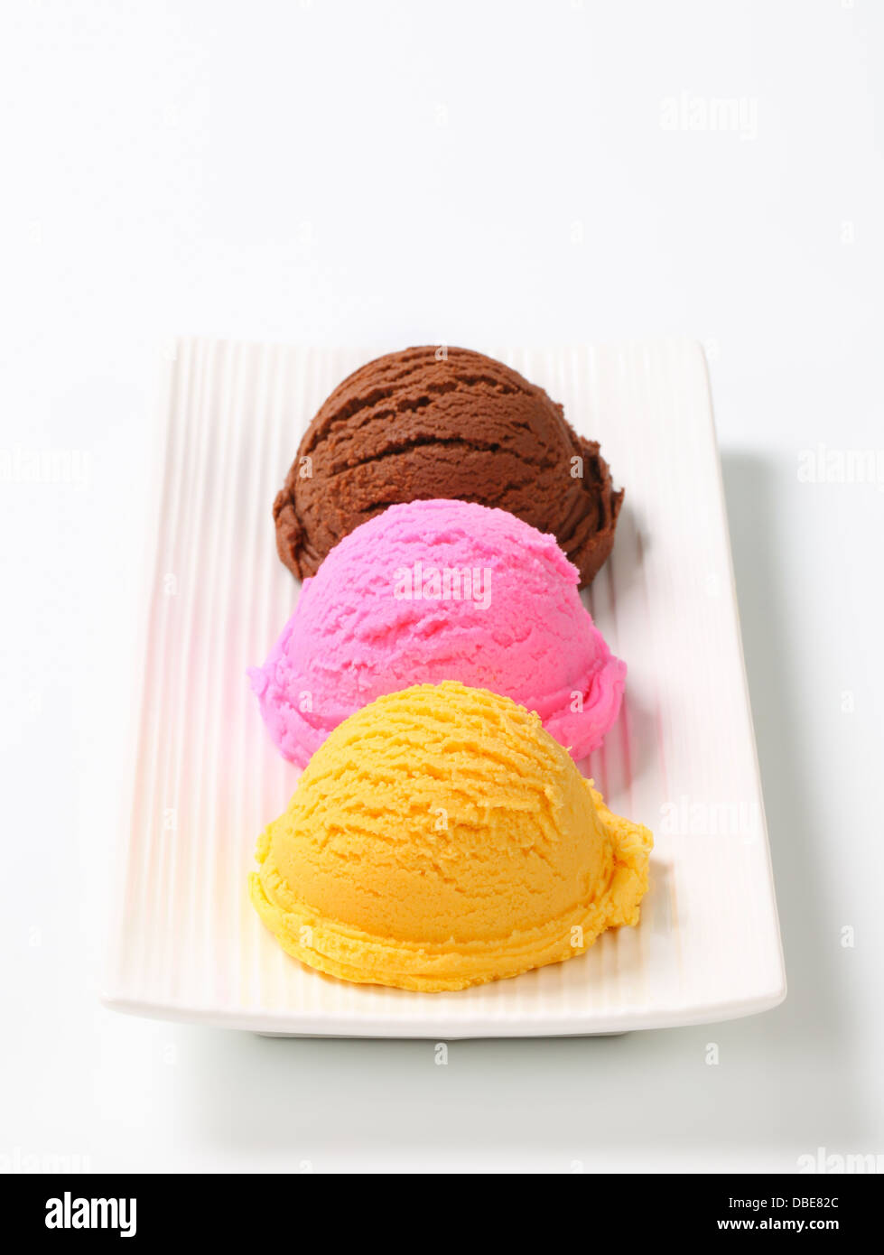 Three scoops of ice cream on a long plate Stock Photo - Alamy