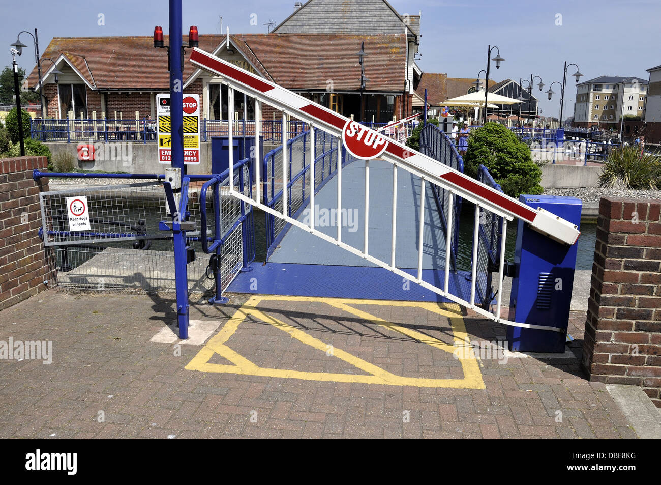Pedestrian footbridge over water with stop barriers raising as draw ...