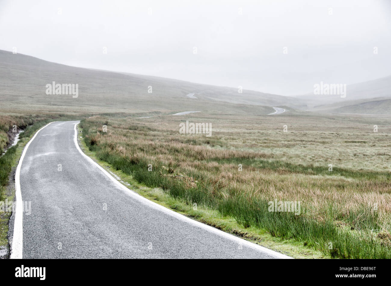 SNOWDONIA NATIONAL PARK, Wales - A road winds its way into the mist on ...