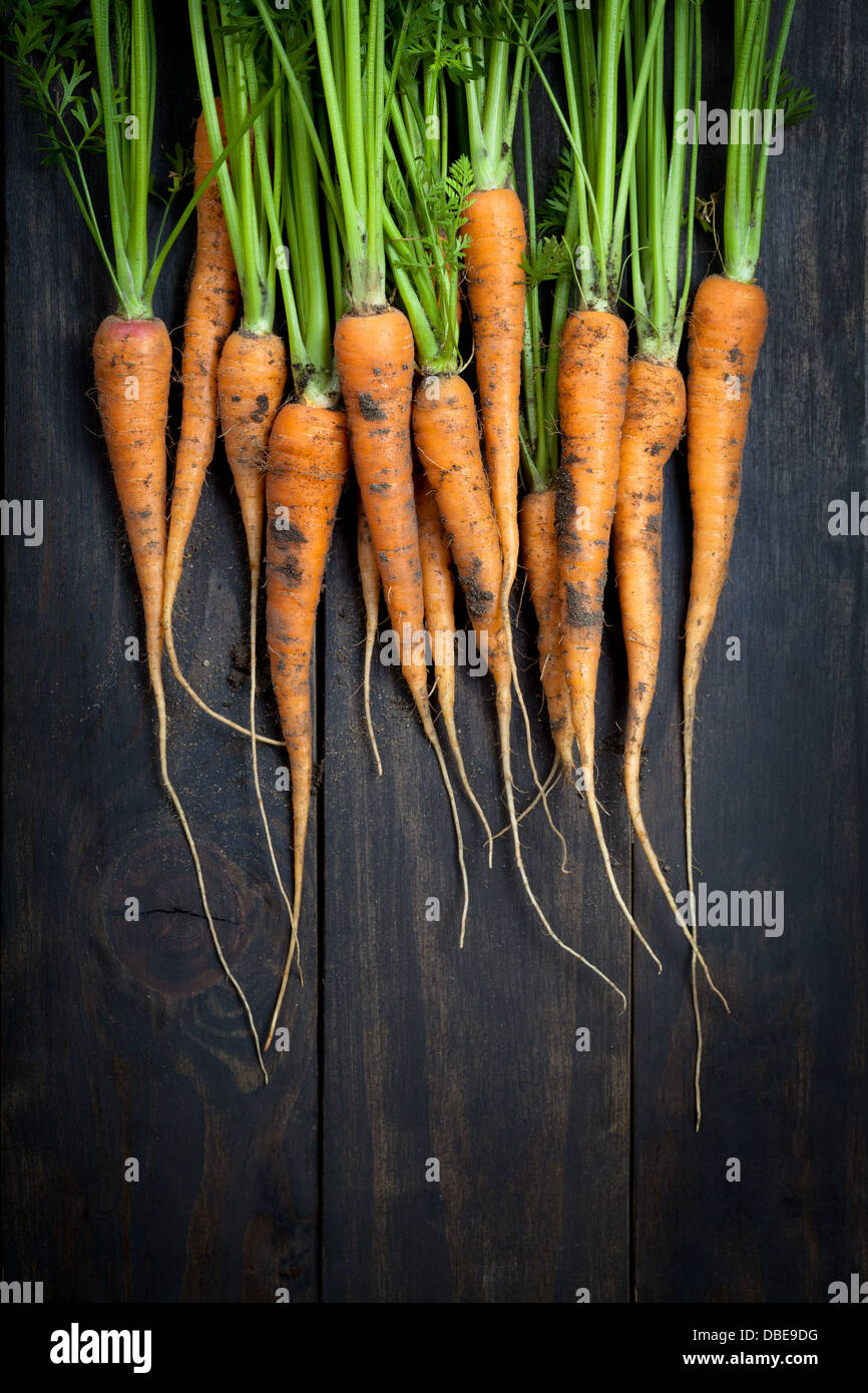 Carrots on wooden table background. Top view Stock Photo - Alamy