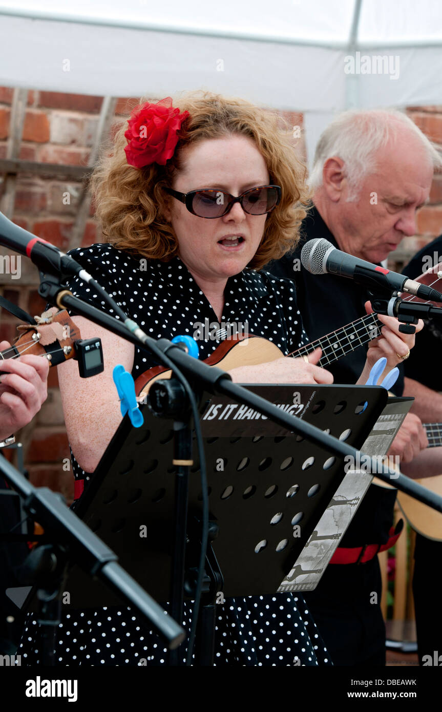 Woman singing and playing a ukulele Stock Photo - Alamy