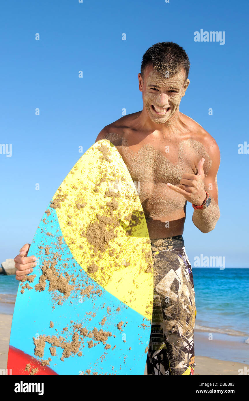 Handsome surfer dirty with sand posing in the beach Stock Photo - Alamy