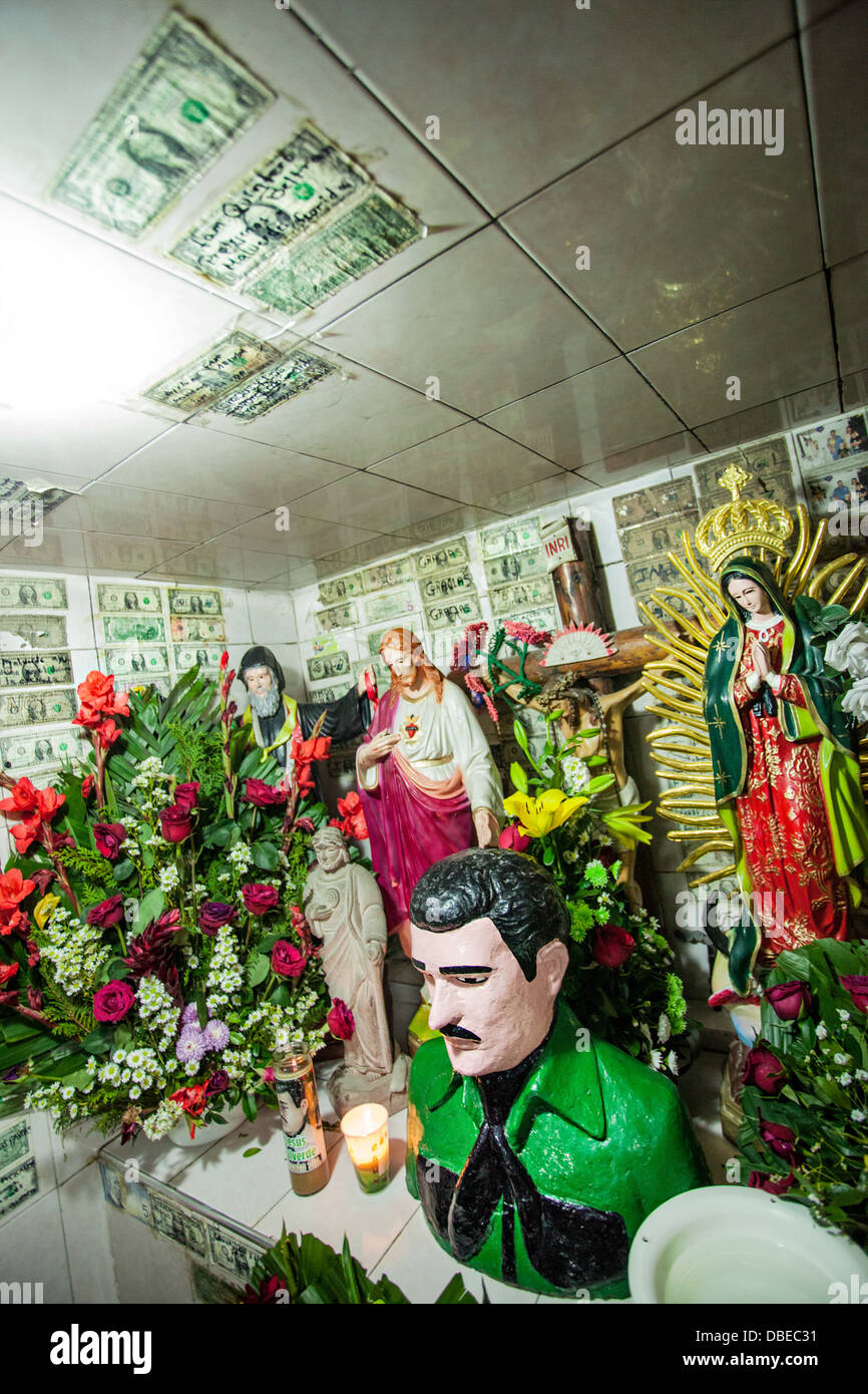 Dollar bills are taped to the wall and ceiling of a shrine dedicated to ...