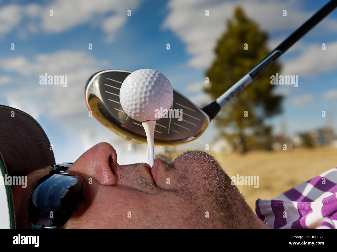 A golfer holding a tee in his mouth Stock Photo - Alamy