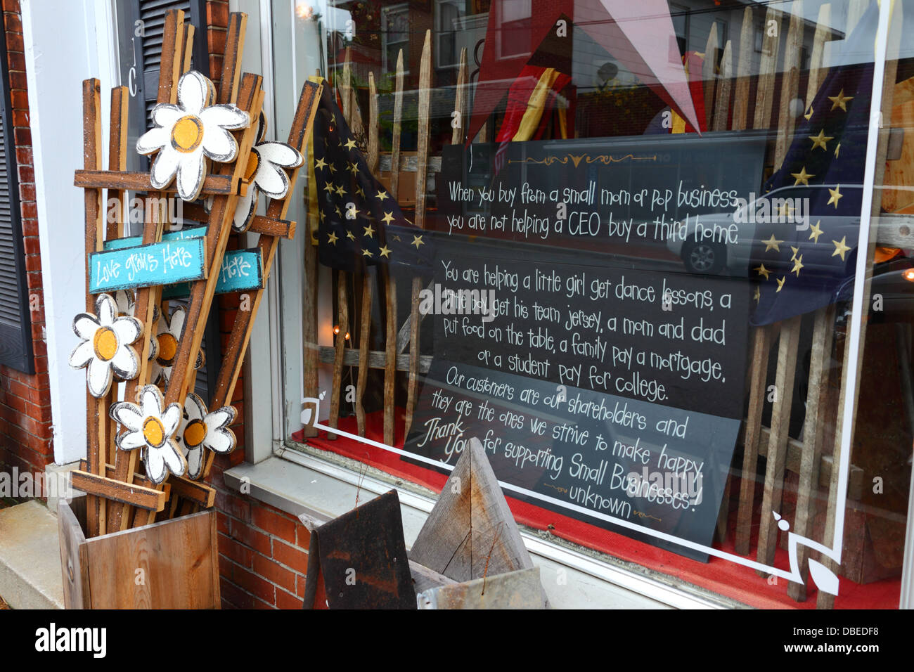 Sign in shop window encouraging people to buy from small businesses ...