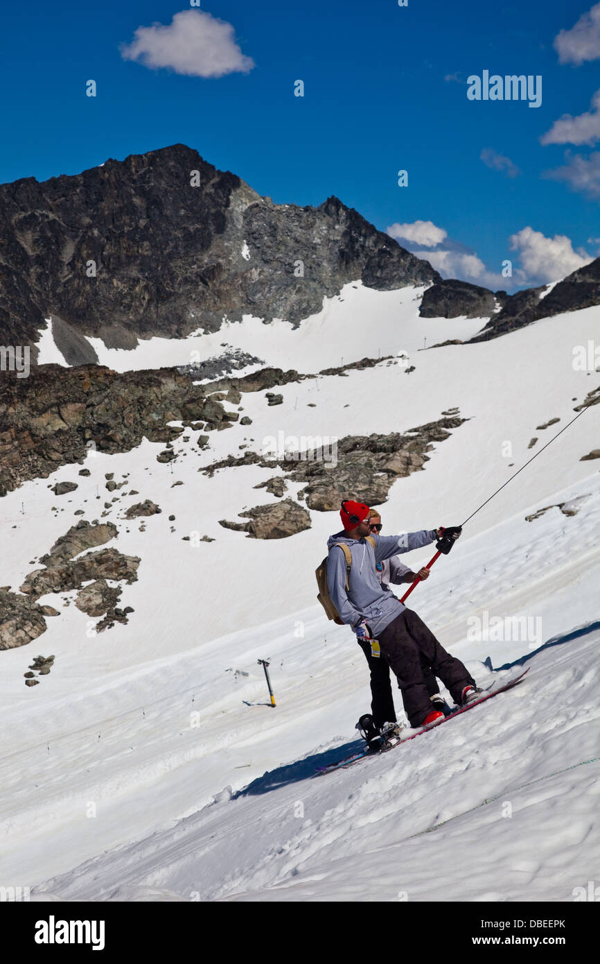 Two snowboarders on a Tee-bar on Blackcomb Mountain in mid-summer Stock ...