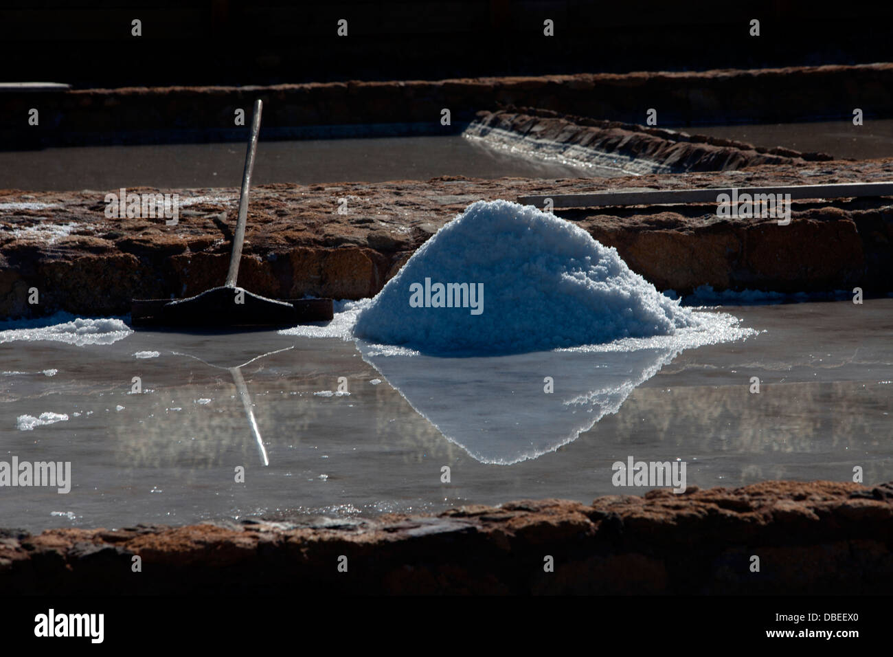 Reflection of a pile of salt and a wooden rake at the Salinas de ...