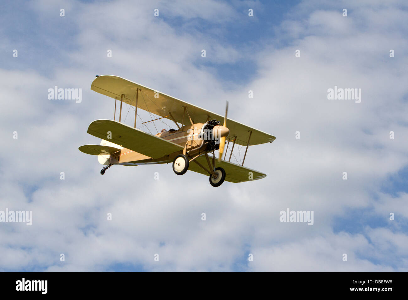 Biplane in flight against a blue sky with cumulus clouds Stock Photo ...