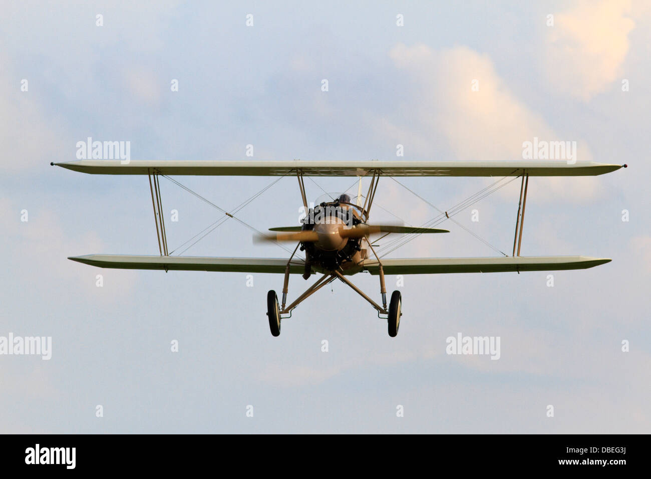 Biplane in flight against a blue sky with cumulus clouds Stock Photo ...