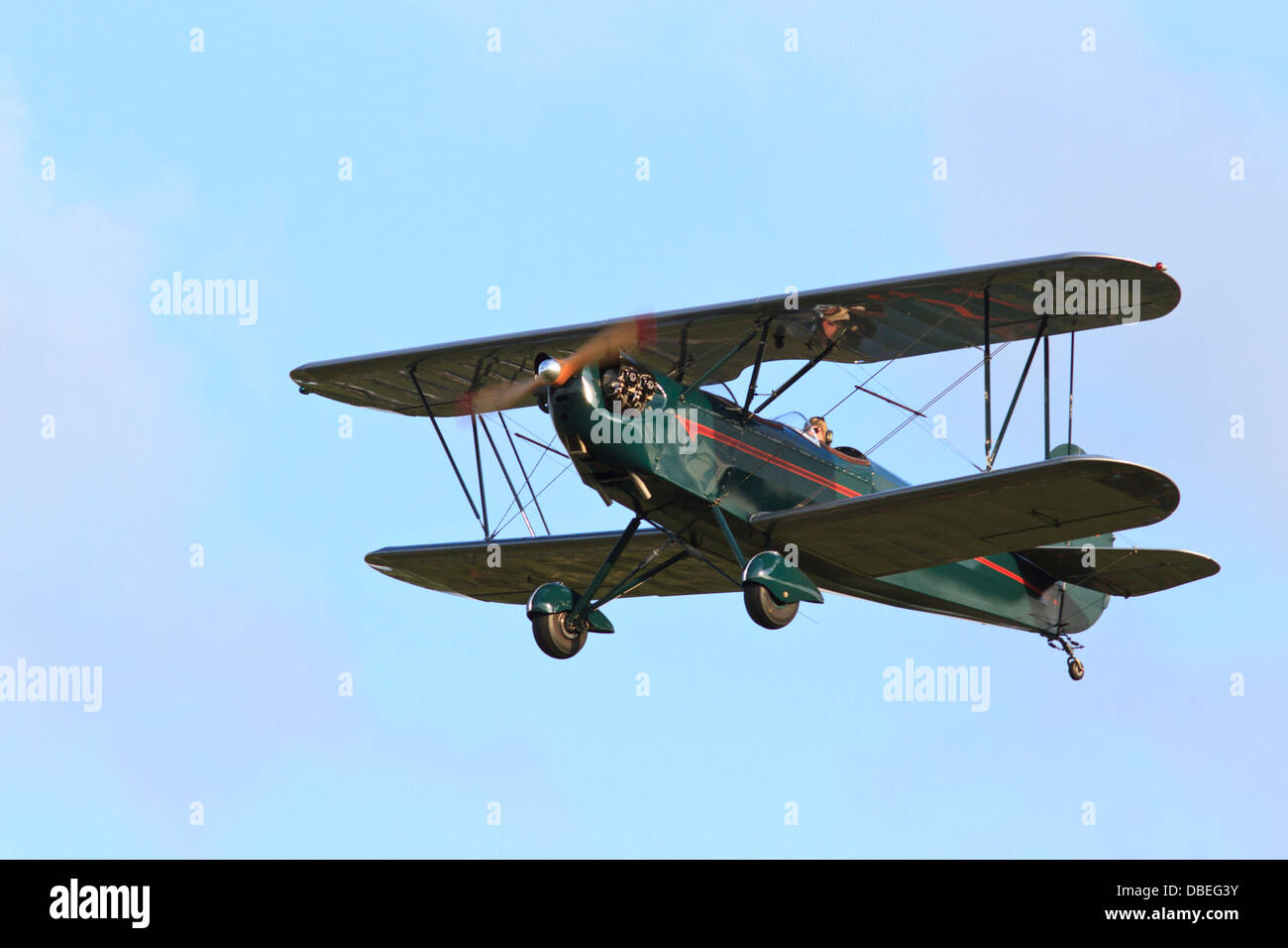 Biplane in flight against a blue sky with cumulus clouds Stock Photo ...
