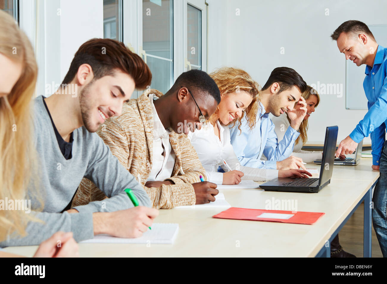Students learning with teacher together in a school workshop Stock ...