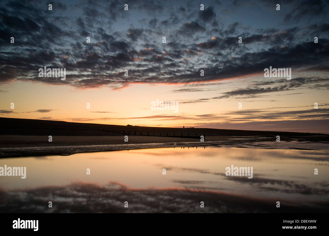 Beautiful sunrise reflected in low tide water pools on beach landscape ...