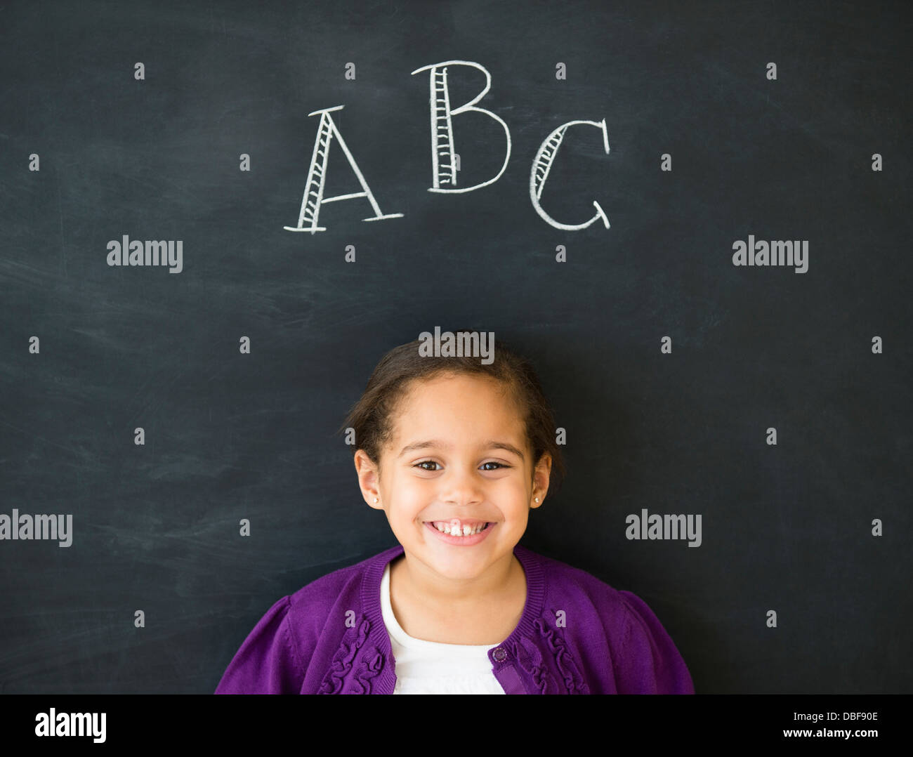 Hispanic girl standing under 'ABC' on chalkboard Stock Photo - Alamy