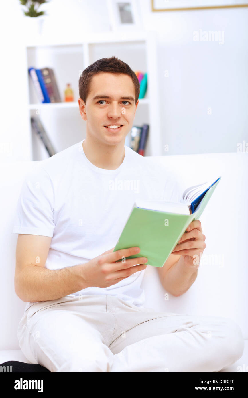 Young man at home with a book Stock Photo - Alamy