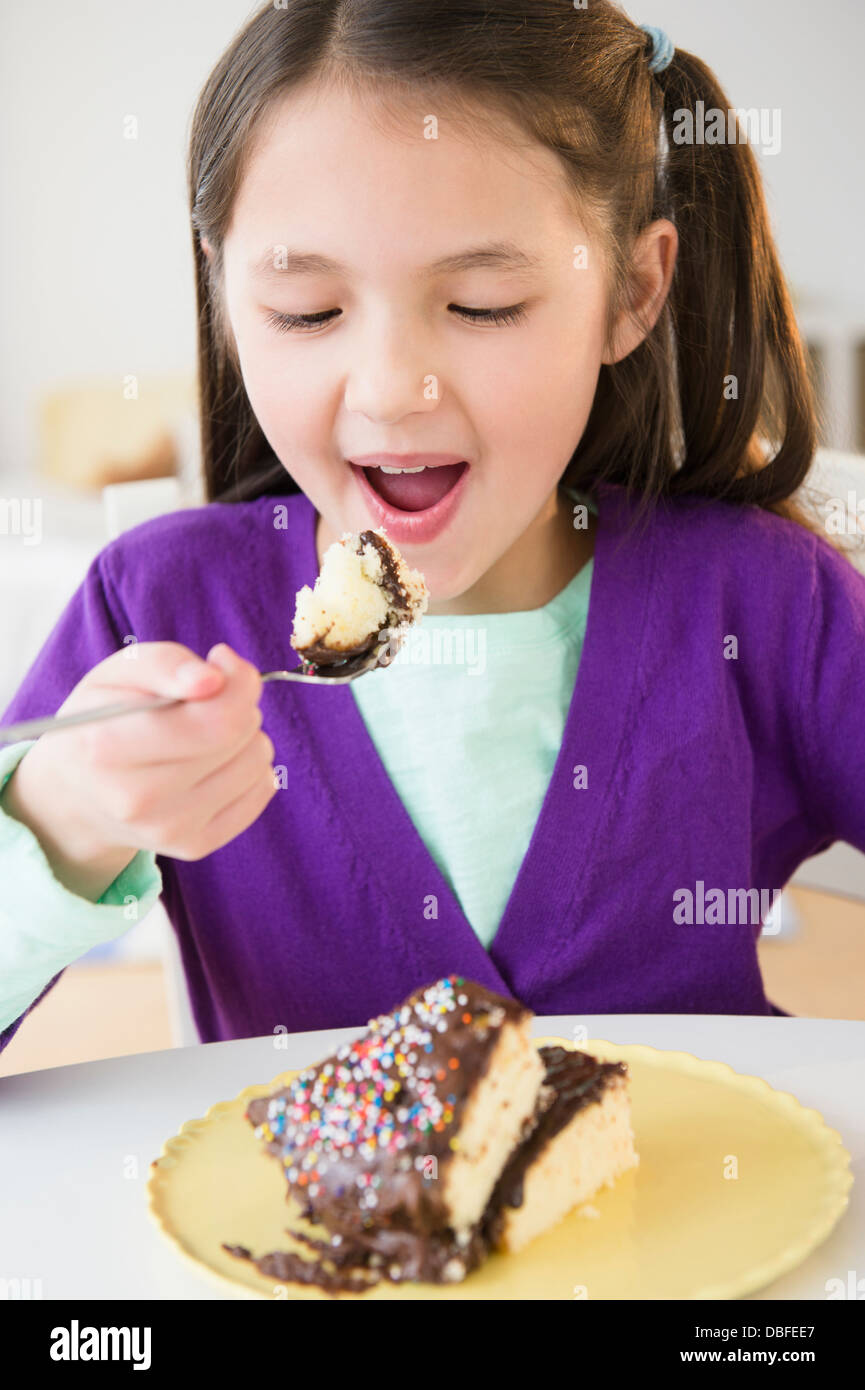 Mixed race girl eating cake Stock Photo - Alamy