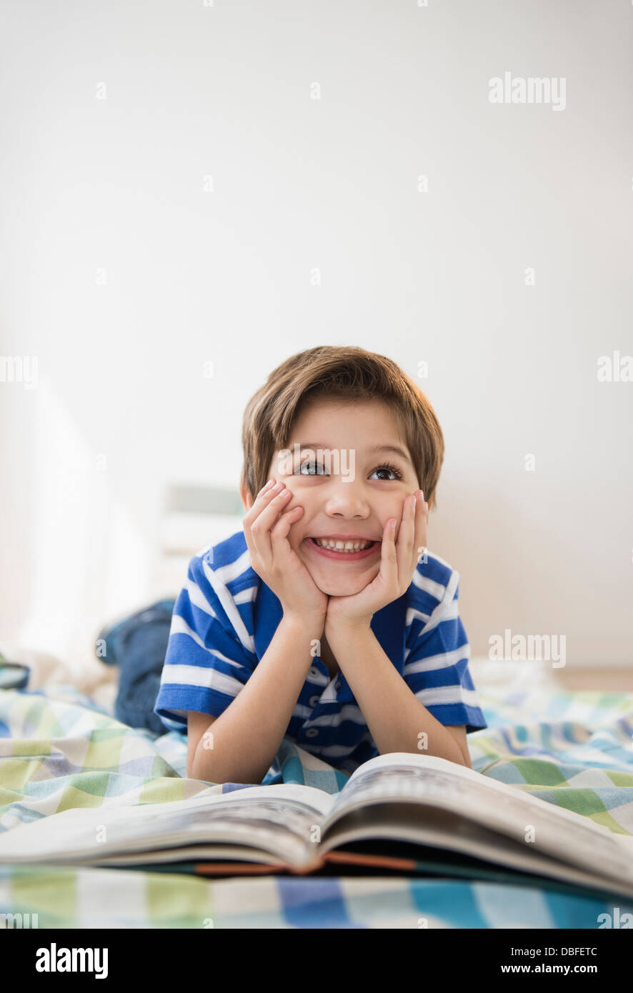 Hispanic boy reading on bed Stock Photo - Alamy
