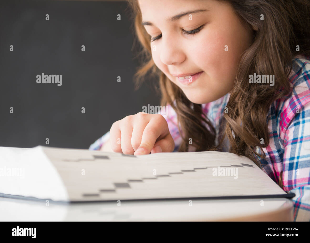 Hispanic girl looking up word in dictionary Stock Photo - Alamy