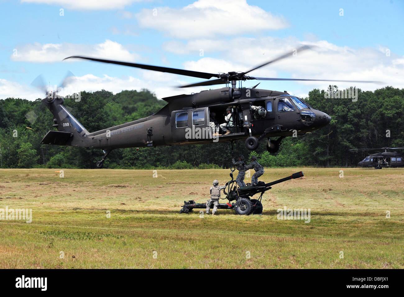 The crew of a 105-mm howitzer sling-loads their cannon to a Black Hawk ...