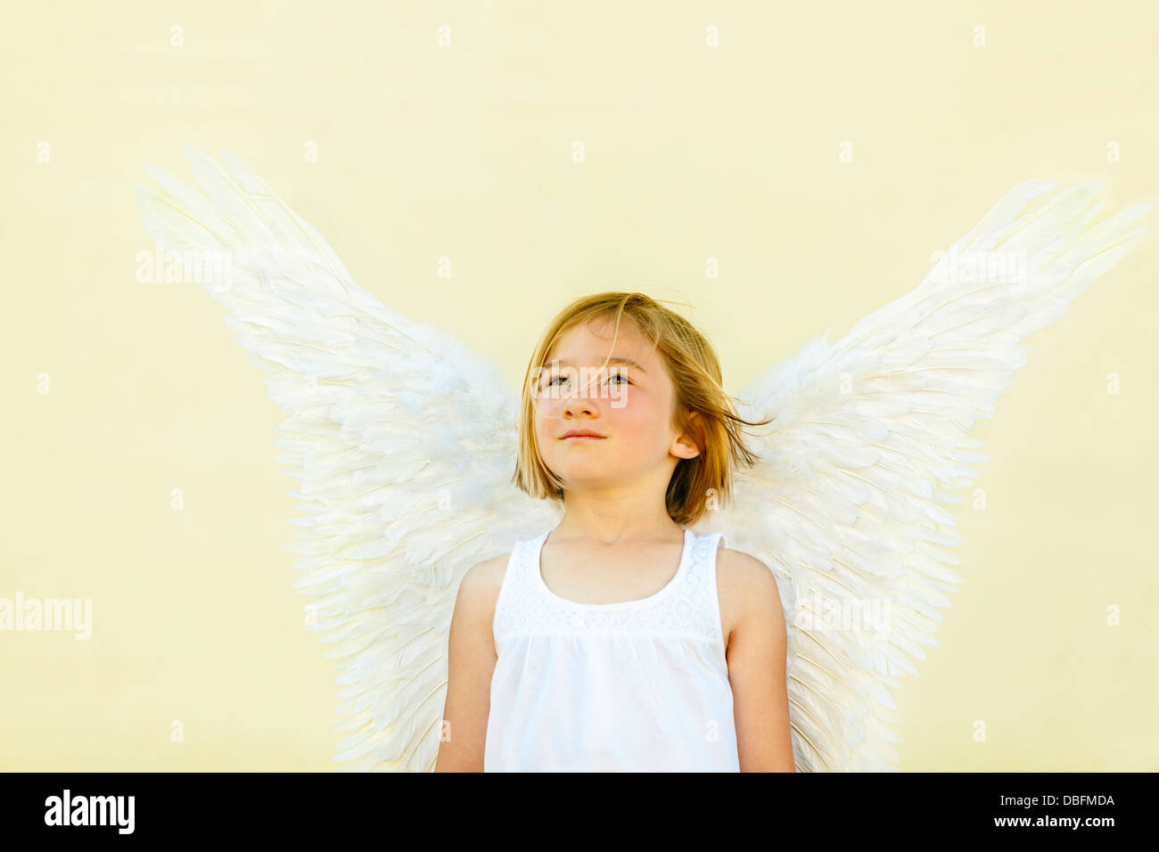 Smiling girl wearing angel wings Stock Photo - Alamy