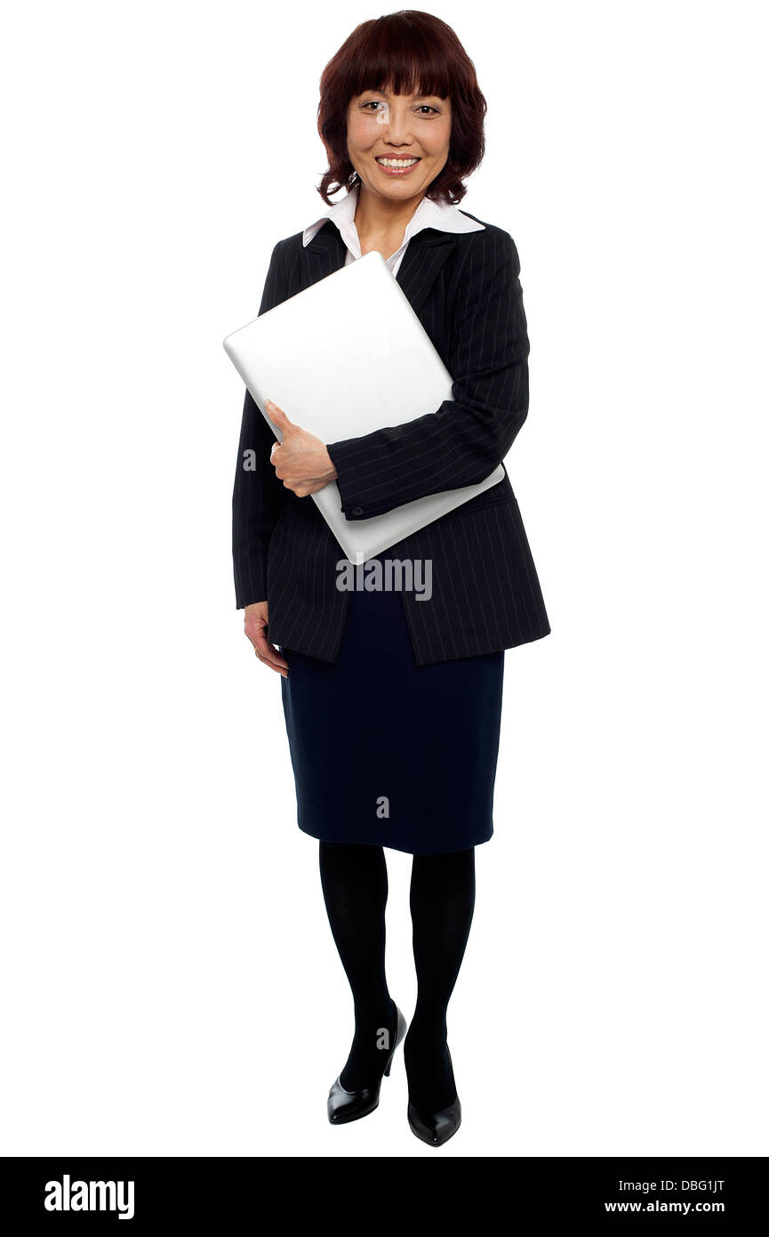 Female executive posing with laptop, full length shot Stock Photo - Alamy
