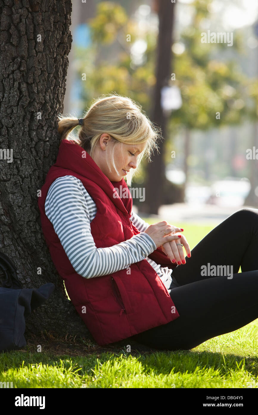 Woman sitting against tree trunk hi-res stock photography and images ...