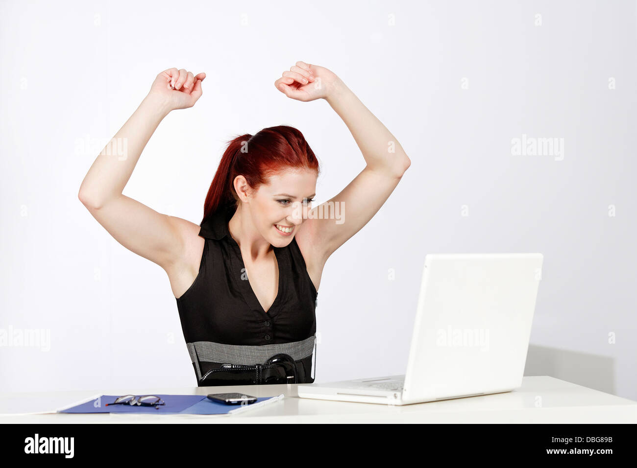 Woman celebrating at work Stock Photo - Alamy