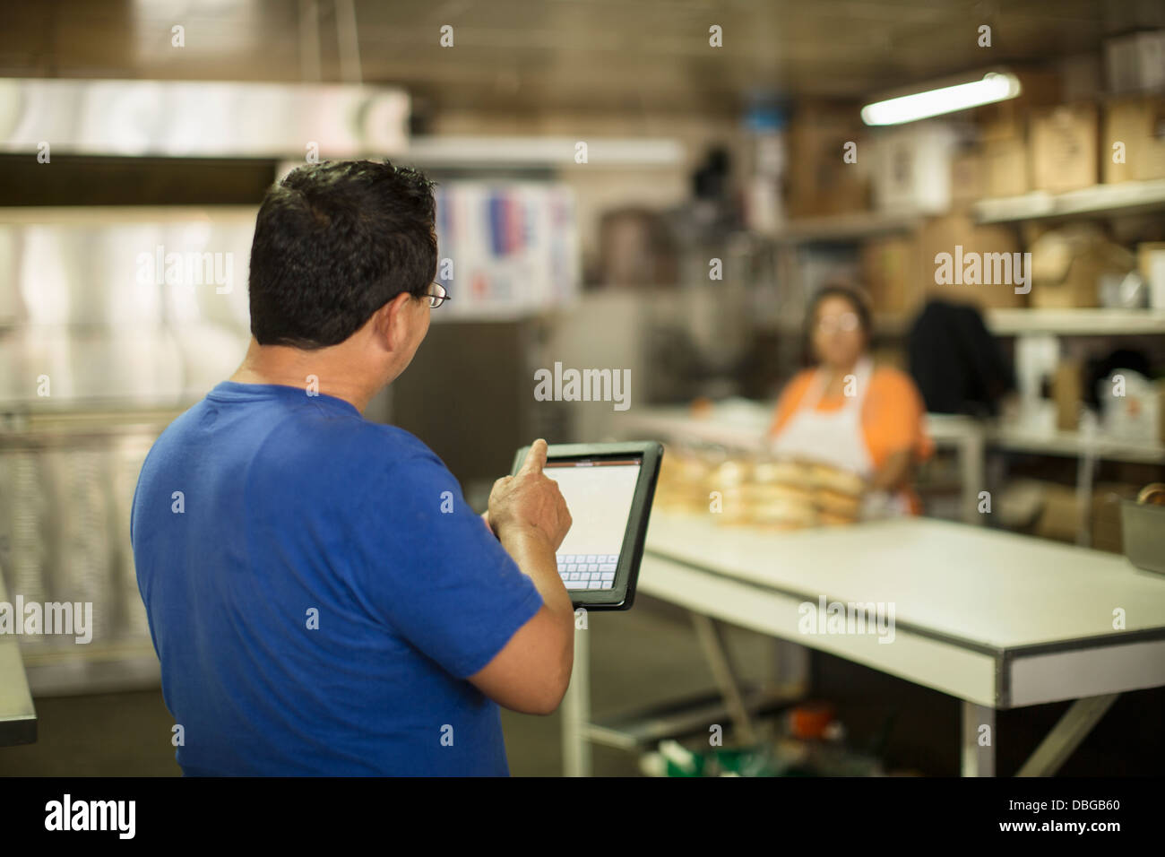 Hispanic baker using tablet computer in kitchen Stock Photo - Alamy