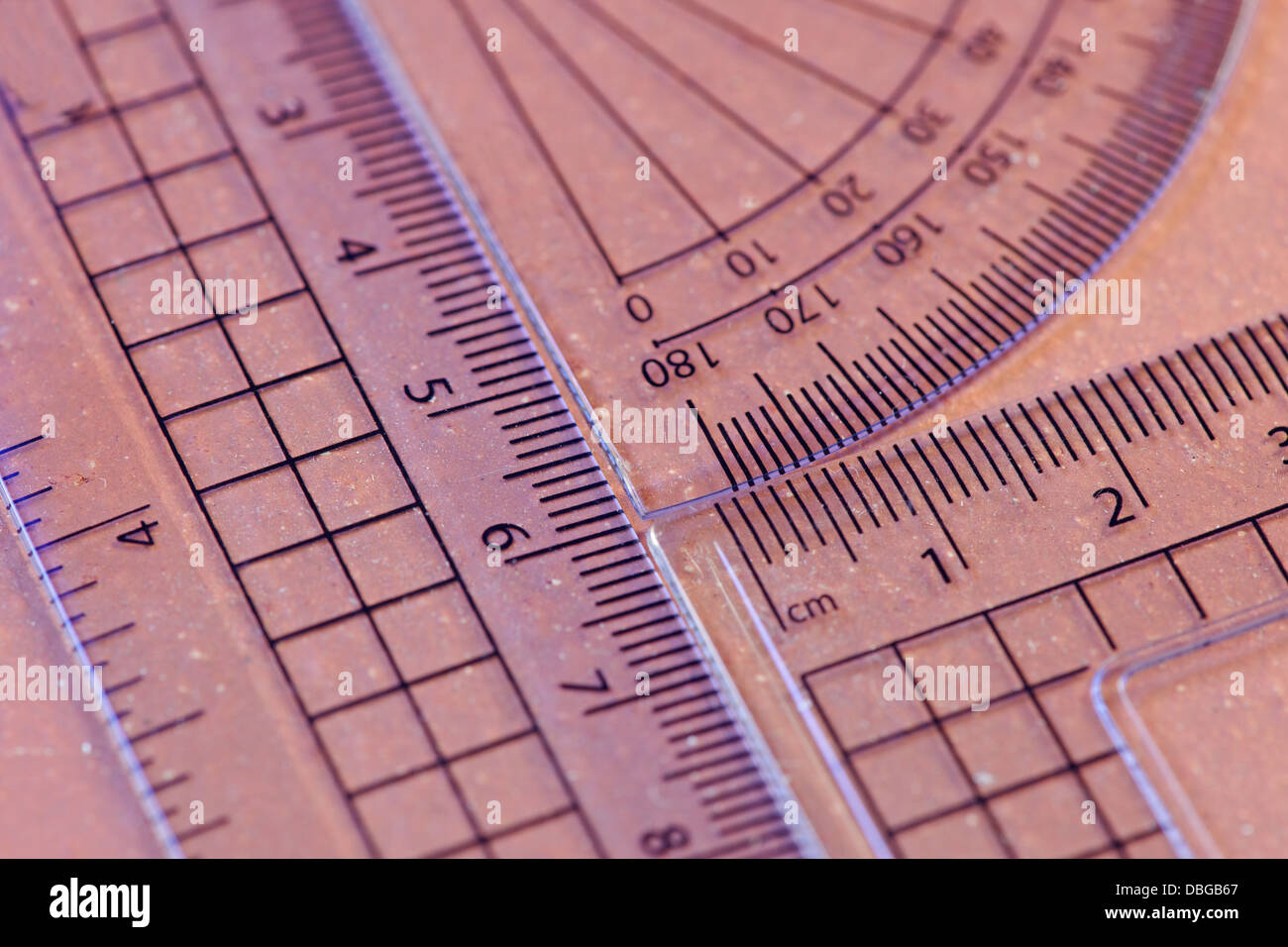Close up of a protractor, set square and ruler with blue edges on tile ...
