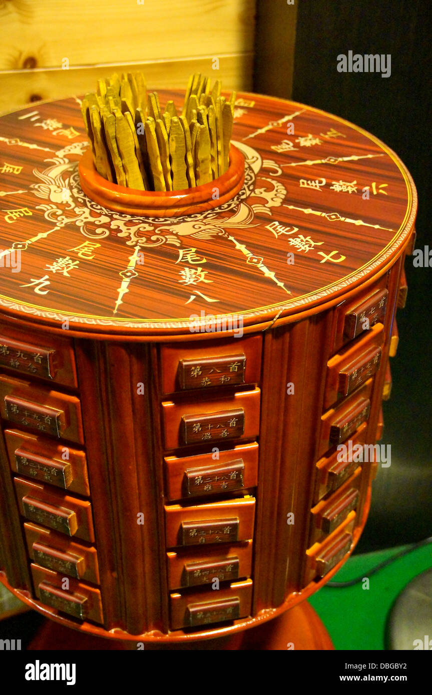 Pray and draw divination sticks at a temple Stock Photo - Alamy