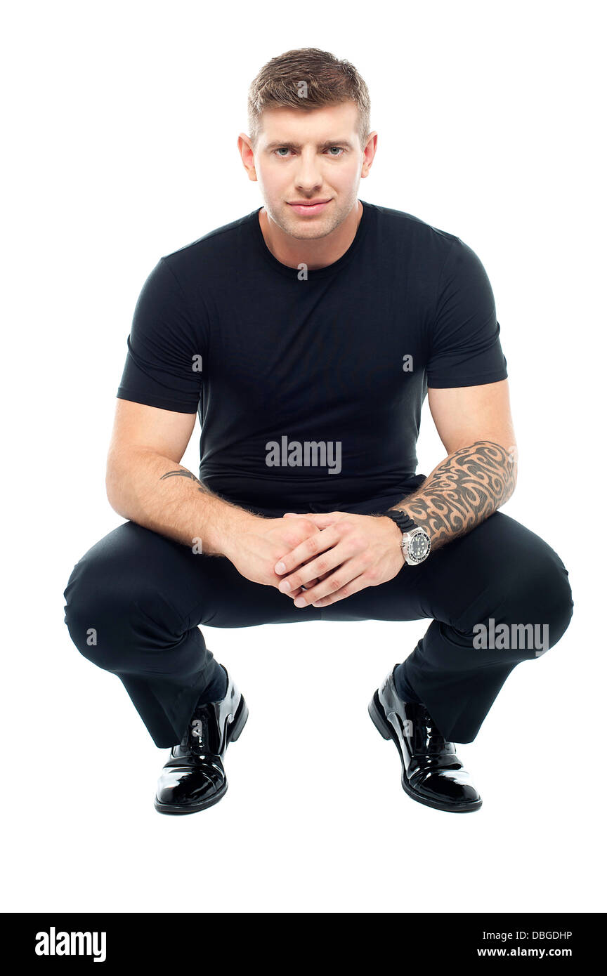 Handsome male bouncer squatting position Stock Photo - Alamy