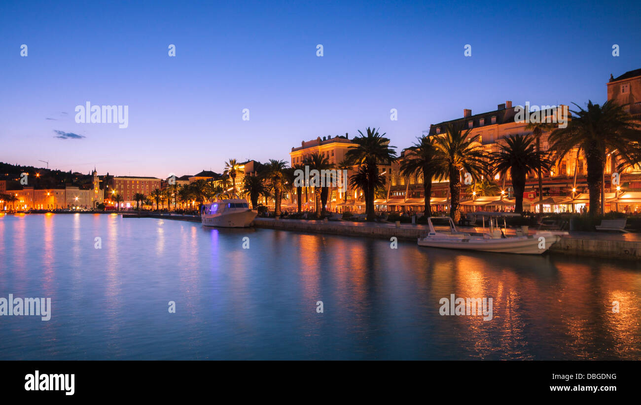 Boats are moored alongside the Riva in Split, Croatia, lined by palm ...