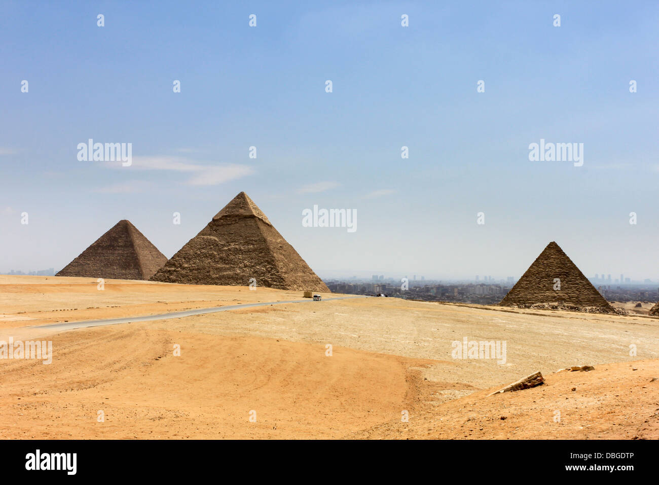 A photograph of the pyramids of Giza with the city of Cairo in the ...