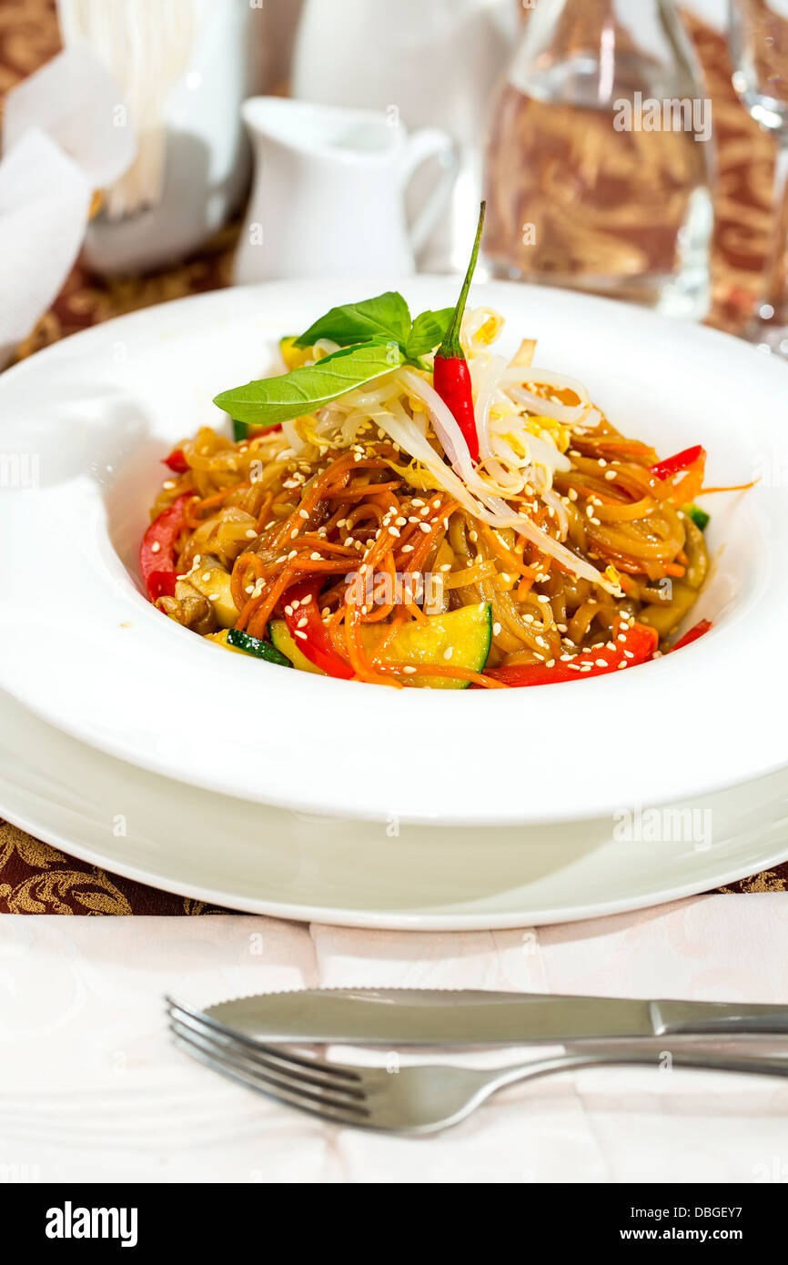 Rice spaghetti with vegetables on a white plate in a restaurant Stock ...