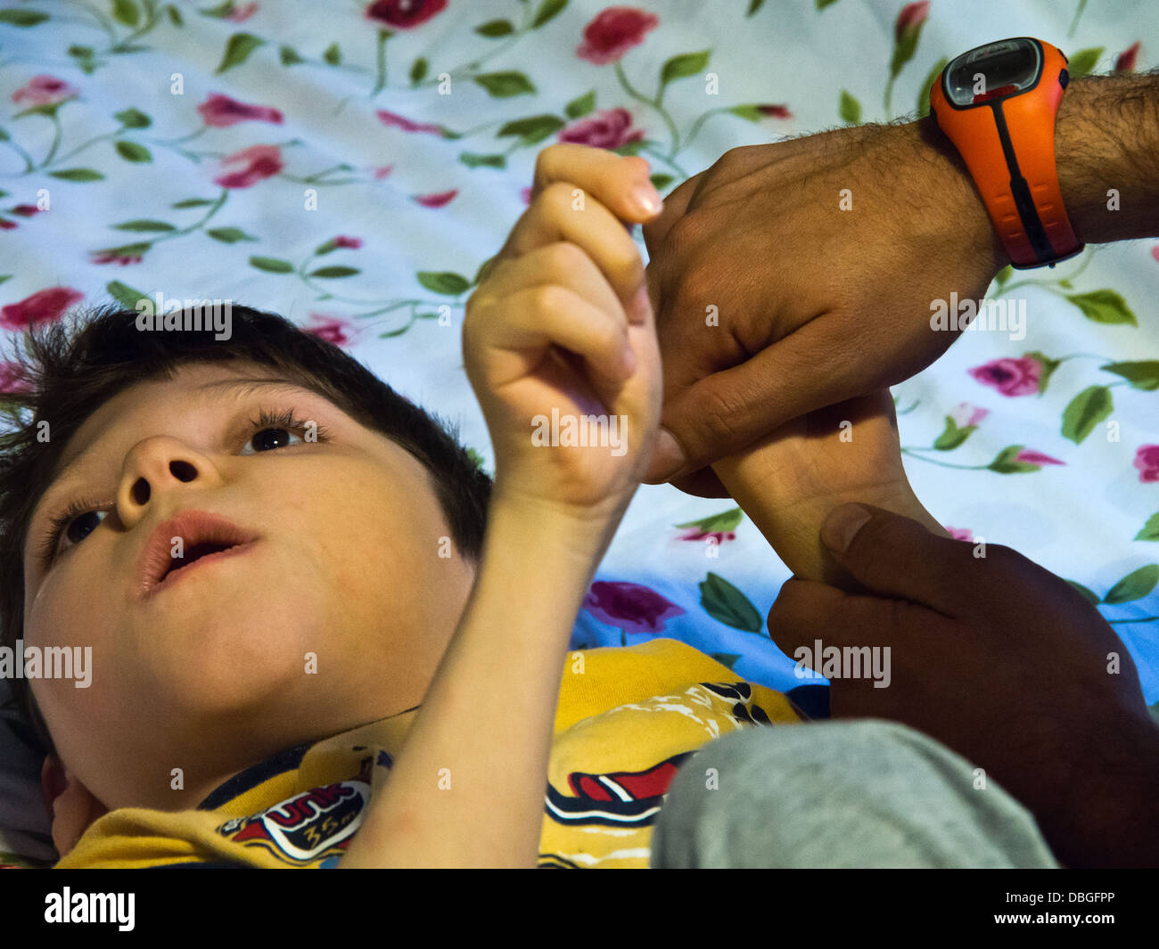 A young boy undergoes rigorous stretching exercises in physiotherapy ...
