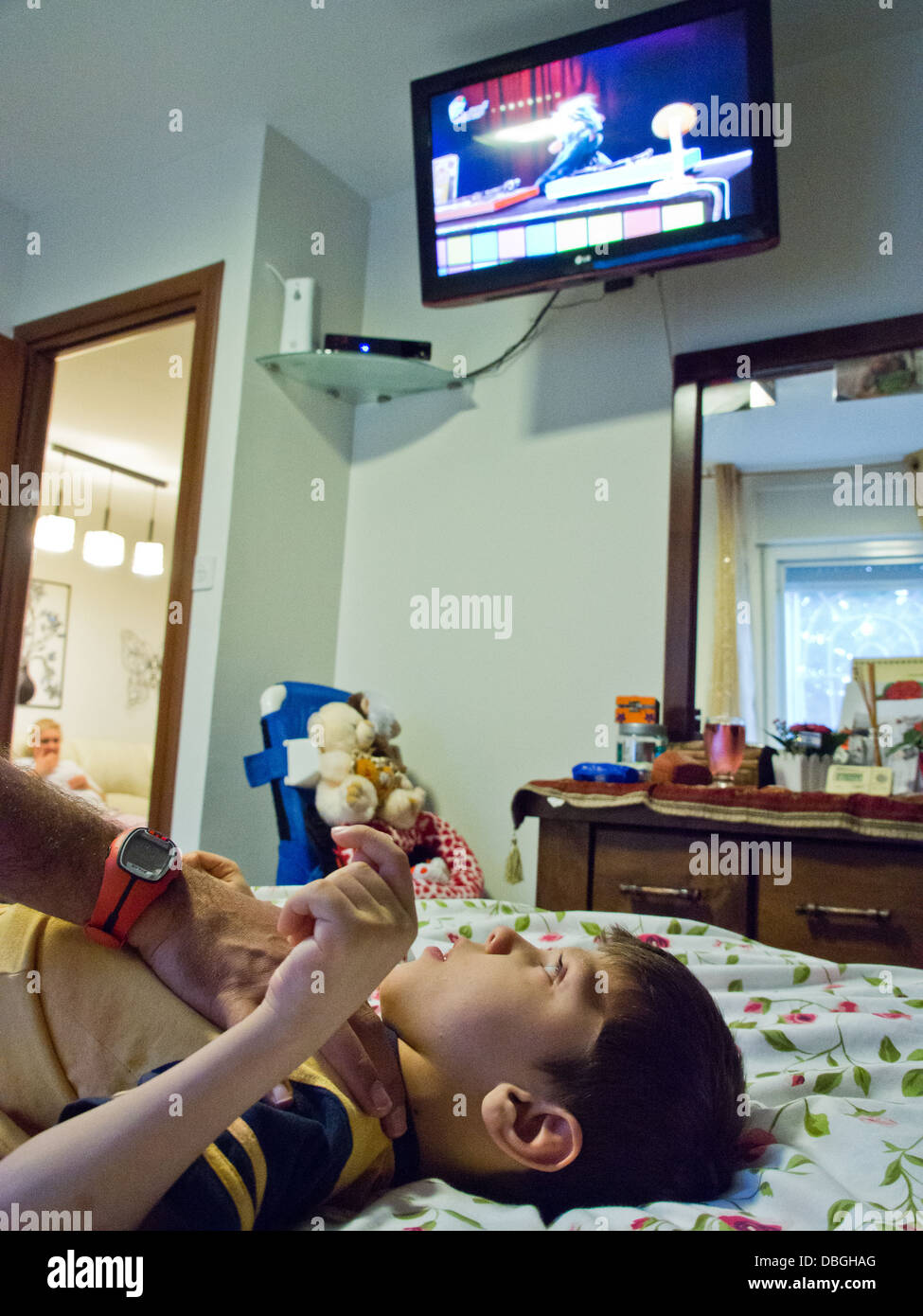A young boy undergoes rigorous stretching exercises in physiotherapy ...