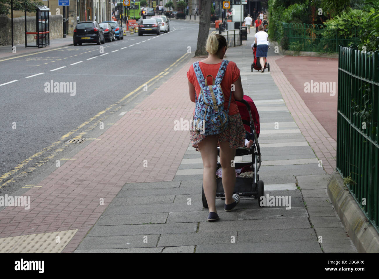Women walking down the pavement outside Mowbray park, pushing ...