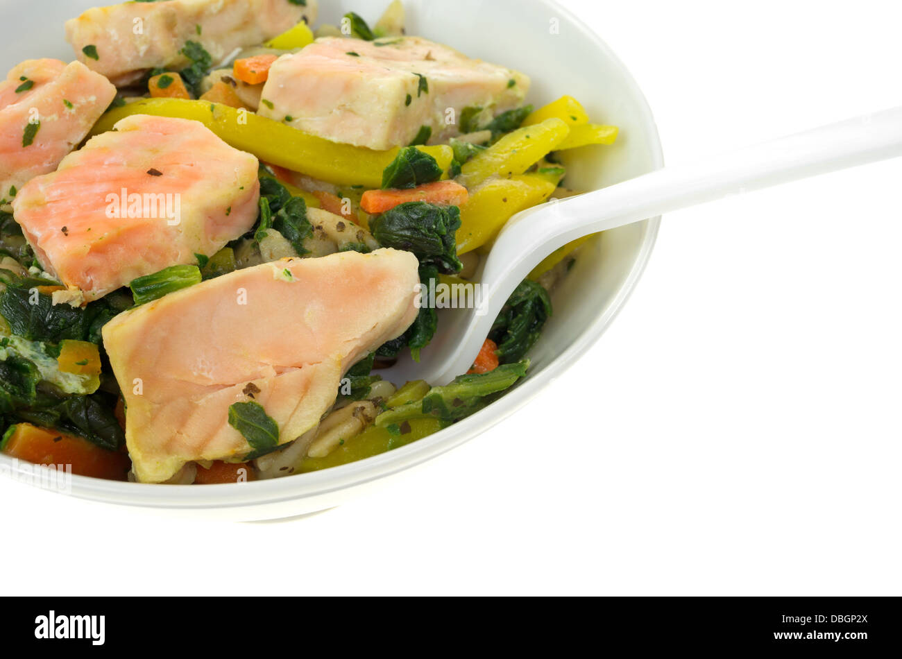 A close view of salmon chunks with assorted vegetables in a bowl with a ...