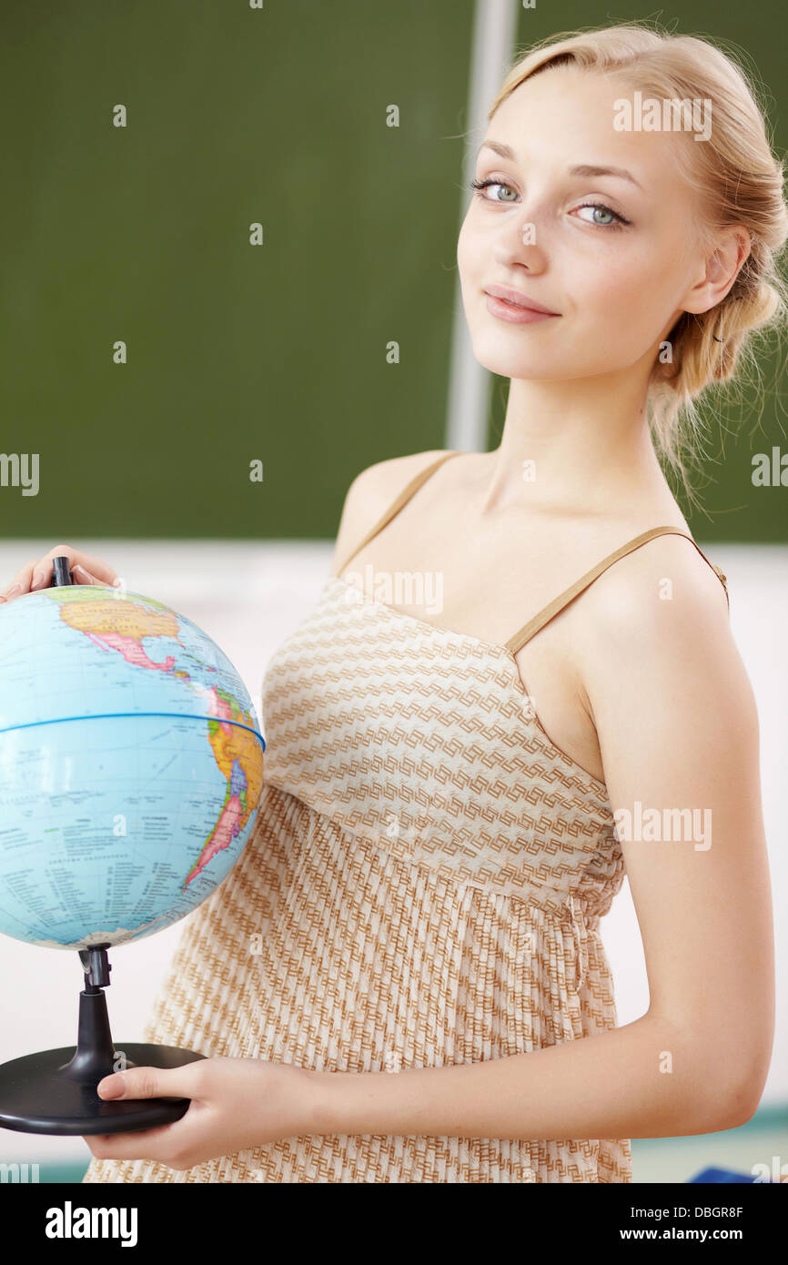 Teacher at school with a globe Stock Photo - Alamy