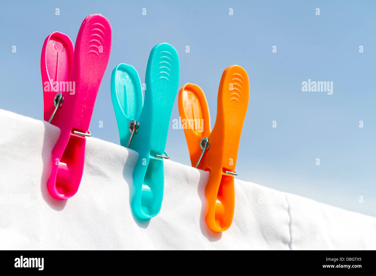 Three clothes pegs on a line Stock Photo - Alamy