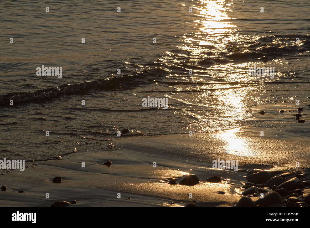 Sunset reflected on sandy beach Stock Photo - Alamy