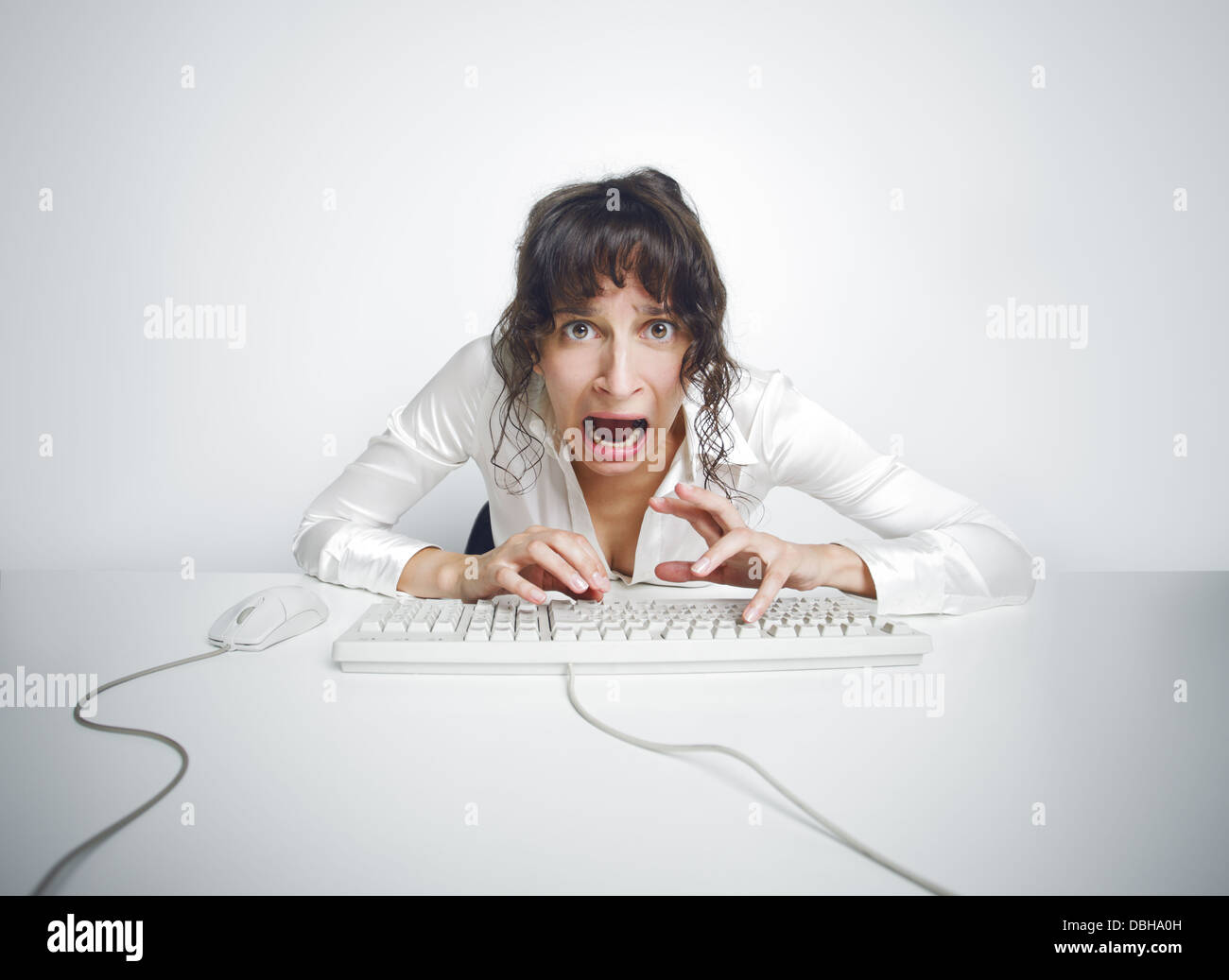 Scared woman at her office desk Stock Photo - Alamy