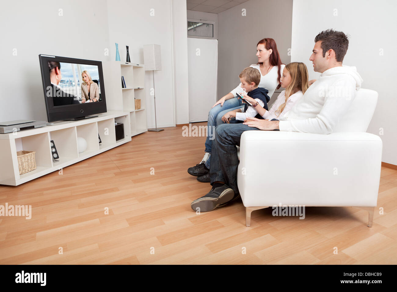 Young family watching TV at home Stock Photo - Alamy