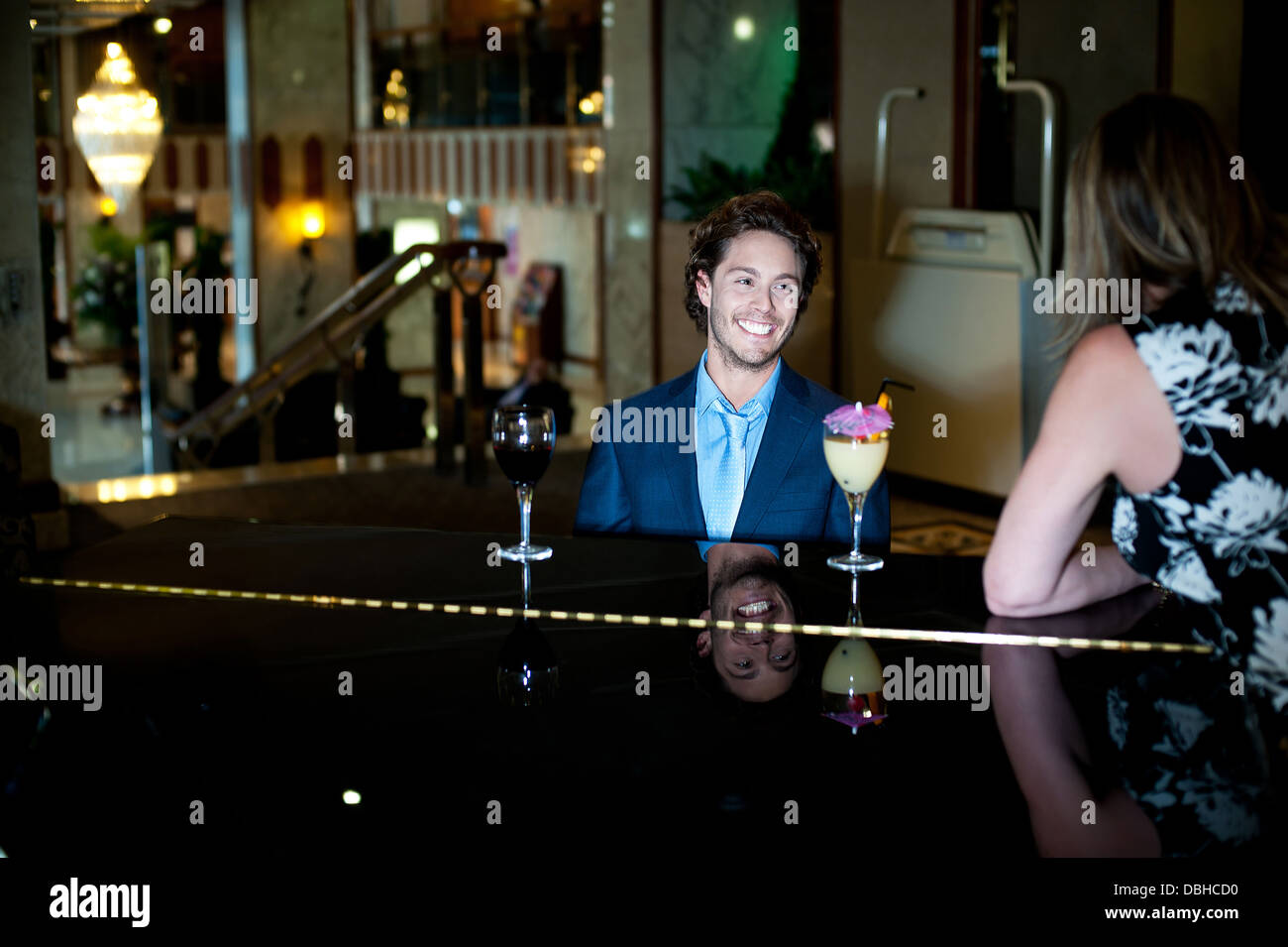 Couple enjoying soothing music as guy plans piano Stock Photo - Alamy