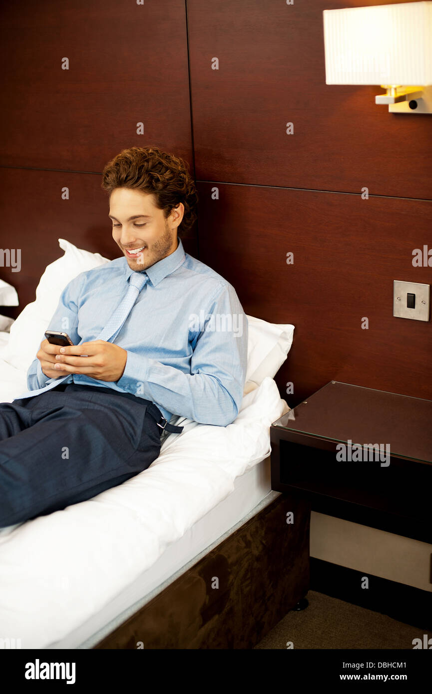 Smiling man sending message to friends hi-res stock photography and ...