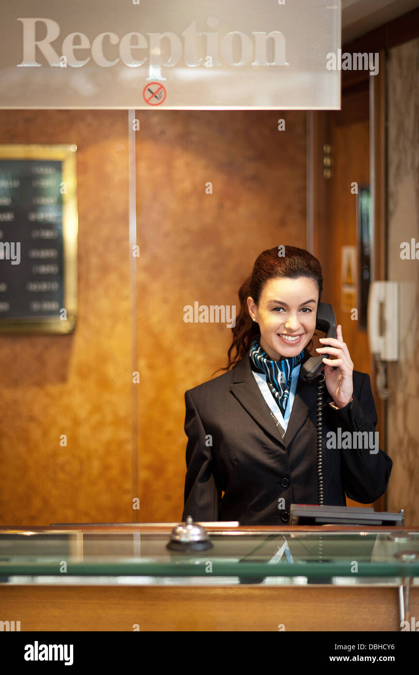 Attractive young receptionist receiving calls Stock Photo - Alamy