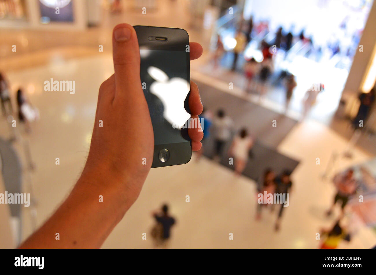 The Apple Store's logo is reflected in the touch screen of an iPhone in ...