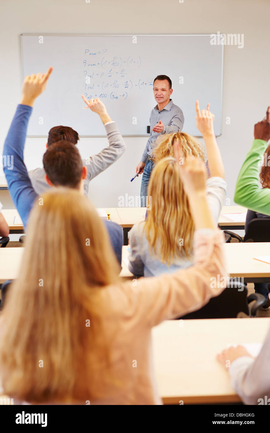 Students answering question in school class with teacher on whiteboard ...