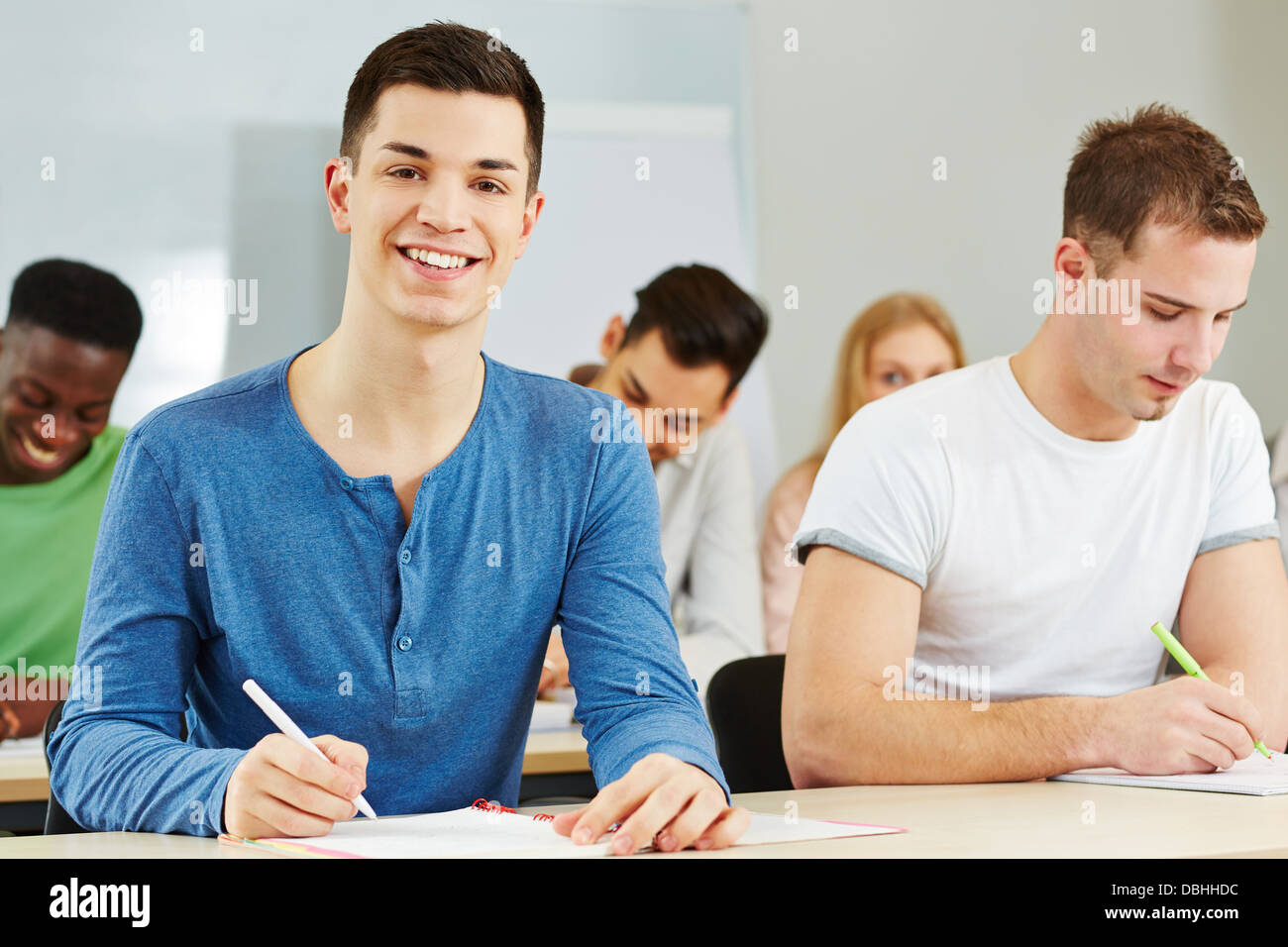 Happy student learning in school in a classroom Stock Photo - Alamy